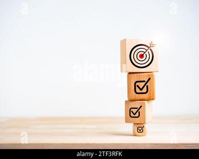 Big target icon on the top of smaller bullseye symbol on wooden cube ...