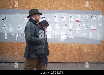 A row of ripped and torn posters which displayed the names and faces of ...
