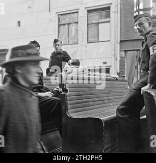 Police conducting a black market raid, searching suspects ca. October ...