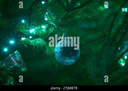 Close up of holiday electric blue garlands on fir branch with Christmas ...