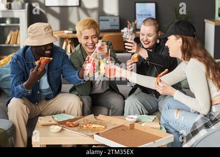 Multi-ethnic students partying at home at night with colorful neon ...