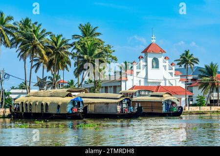 Indian traditional houseboats anchored at Pamba river coastline, with ...