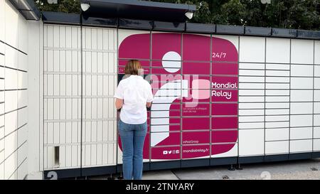 Paris, France - Jul 10, 2023: A woman approaches the Mondial Relay ...