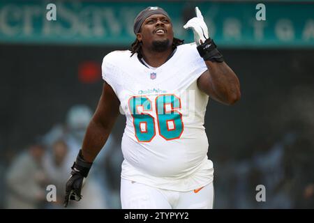 Miami Dolphins guard Lester Cotton (66) reacts after defeating the New ...