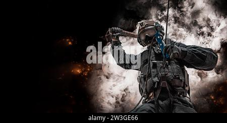 Special forces soldier hangs on a rope and swings with a special device ...
