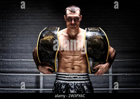 Kickboxing world middleweight champion stands with two belts. The ...