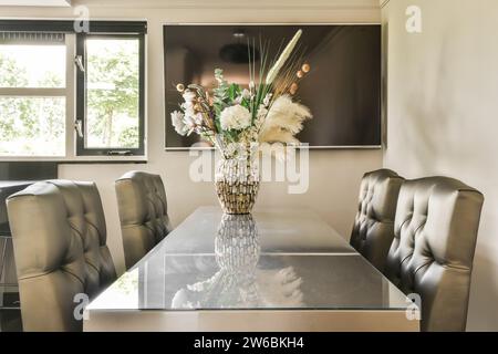 Dining table, vase of pampas grass and wine bottle in room Stock Photo ...
