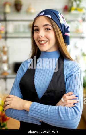 Positive young female seller wearing uniform showing iberian ham in ...