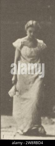 A woman in a long dress stooping down to lift a handkerchief, captured ...