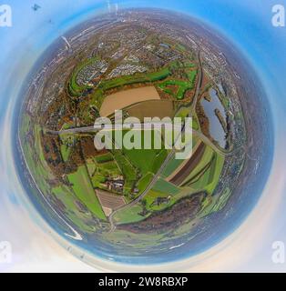 An aerial shot of a highway surrounded by green trees and a dry sandy ...
