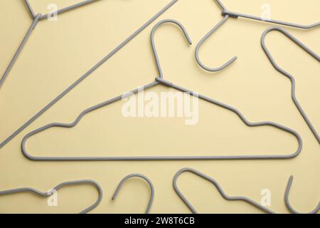 Hangers on pale yellow background, flat lay Stock Photo - Alamy