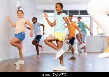 Energetic tween girl practicing vigorous movements in children dance ...