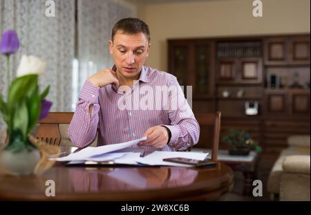 Concentrated man filling out papers Stock Photo - Alamy