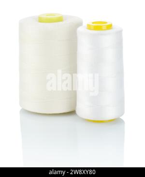 Two spools of colored thread, close-up, on a jute fabric, top view ...