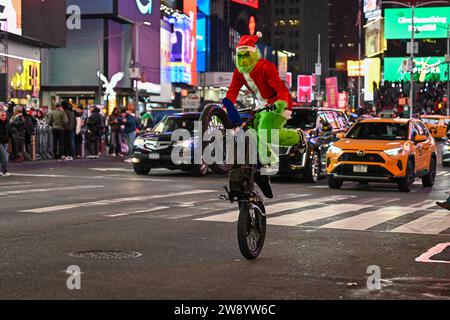 A cyclist dressed as the Grinch rides a bike through Times Square on ...