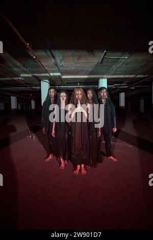 a group of devil worshipers in all black clothes and transparent veils ...