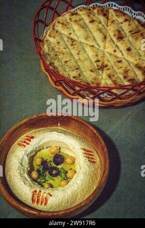 a serving of Cold Mezza - Hummus with olives, chick peas, olive oil ...