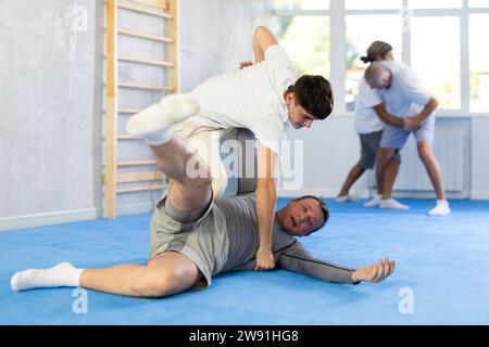Judo lessons - young guy makes power throw during judo or sambo classes ...