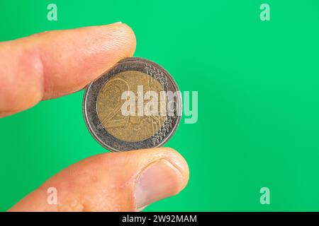 2 euro coin face held between thumb and index finger Stock Photo - Alamy