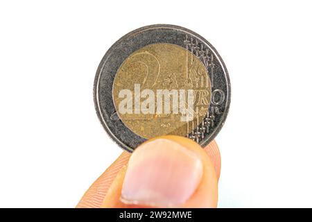 2 euro coin face held between thumb and index finger Stock Photo - Alamy