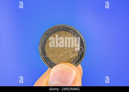 2 euro coin face held between thumb and index finger Stock Photo - Alamy