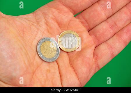 coin face of 2 euro on the palm. green background Stock Photo - Alamy