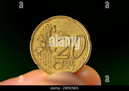20 euro cent coin face held between thumb and index finger Stock Photo ...