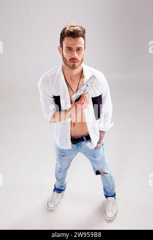 Powerful young man with a gun Stock Photo - Alamy