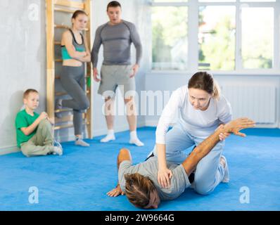 Woman in gym perform basic elements of krav maga self-defense system ...