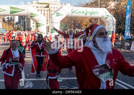Participants dressed as Santa Claus arrive at the finish line during ...