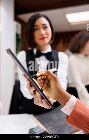 African woman filling out registration form at front desk Stock Photo ...
