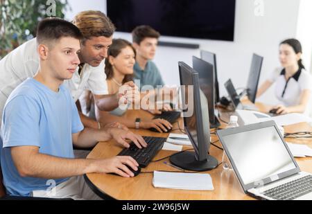 Male instructor assisting motivated guy during computer course Stock ...