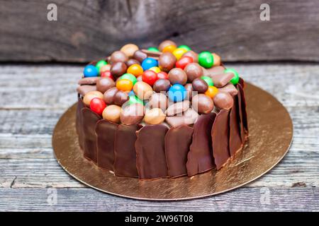 Cake with chocolate fence and scattered colorful chocolate MM bonbon on ...