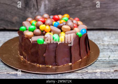 Cake with chocolate fence and scattered colorful chocolate MM bonbon on ...