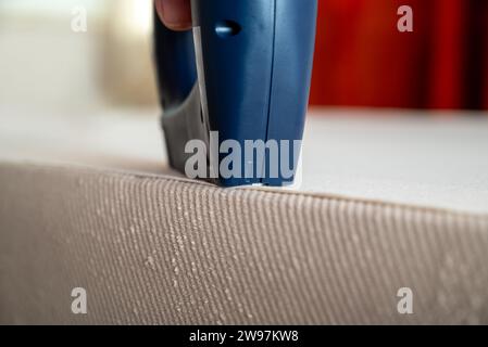 Worker stapling sofa lining with electric staple gun Stock Photo - Alamy