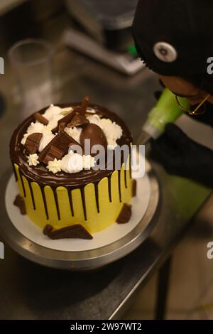 Decorating cup-cake with cream. Using cooking bag, confectioner making ...