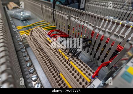 A factory assembly line with an electronic cabinet open, revealing the ...