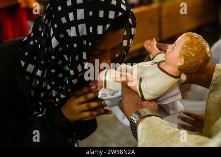 GUWAHATI,INDIA- DECEMBER 25: Devotee kisses the baby idol of Jesus ...