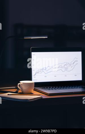 Computer in a dark room with graphs on the screen Stock Photo - Alamy