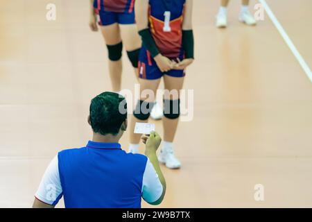Back view of male second volleyball referee stands and assists the main ...