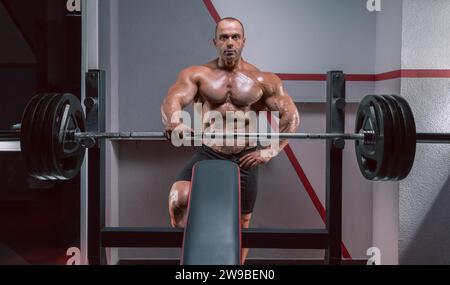 Muscular man stands near the barbell. Bodybuilding concept. Mixed media ...