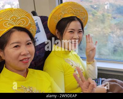Dongxing. 27th Dec, 2023. Passengers in traditional costumes are seen ...