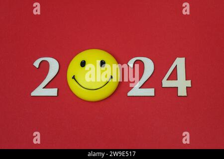 Die Jahreszahl 2024 mit Smiley, umgeben von Girlanden und ...