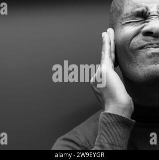 deafness suffering from hearing loss on grey black background with ...