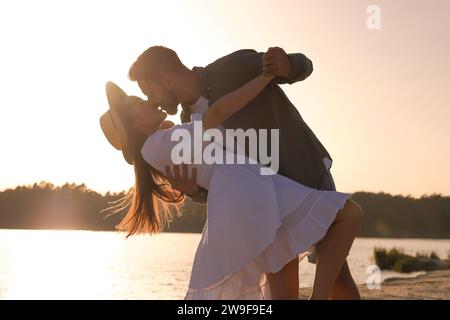 Happy couple dancing and kissing near river Stock Photo - Alamy
