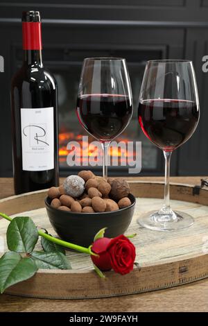 Bottle of wine, chocolate candies, rose flower and gift on pink ...