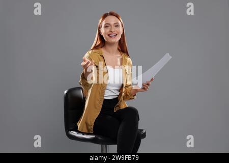 Casting call. Young woman with script performing on grey background in ...