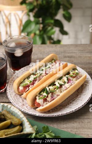 BBQ hot dog served with vegetables and French fries and sauces on ...