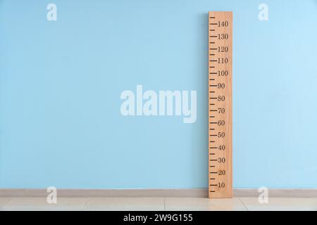 Wooden stadiometer near blue wall Stock Photo - Alamy