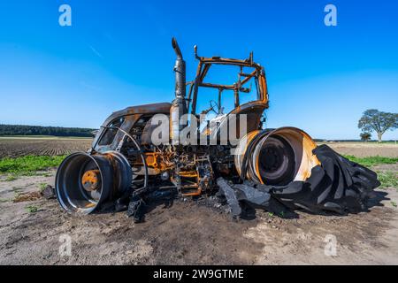 Fully destroyed burnt down tractor on a field Stock Photo - Alamy